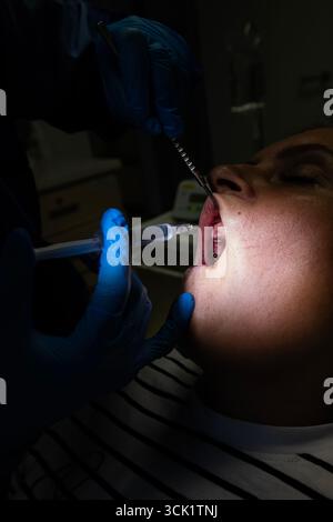 During implant treatment, a doctor performs an injection. The dentist ...