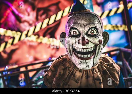 Scary halloween clown with menacing smile holding sack dark room with ...