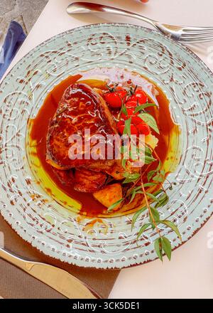 Appetizing roasted potatoes served in white ceramic bowl. Garnished ...