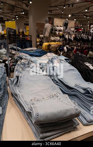 Colorful stacks of folded clothing arranged neatly with price signs in ...