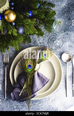 Festive table setting decorated with peacock feather for Christmas ...