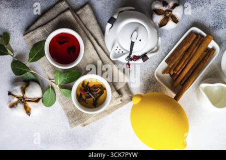 Floral tea concept with tea pot and cups on stone background with copy ...