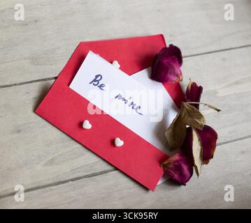 red paper hearts and rose petals on pink background Stock Photo - Alamy