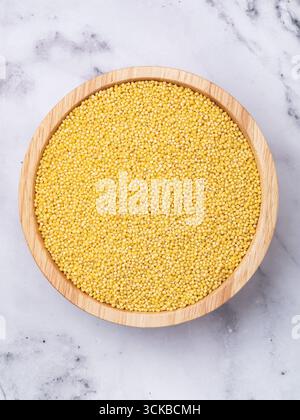 plate with raw cereal millet on a wooden background. preparation of a ...