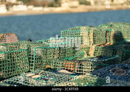 Fishing gear and vibrant nets arranged on quay next to boat in ...