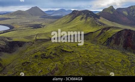 An aerial of a small lake surrounded by rocky mountains in the ...