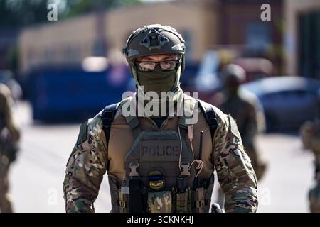 A federal agent waits outside an immigration courtroom as a respondent ...
