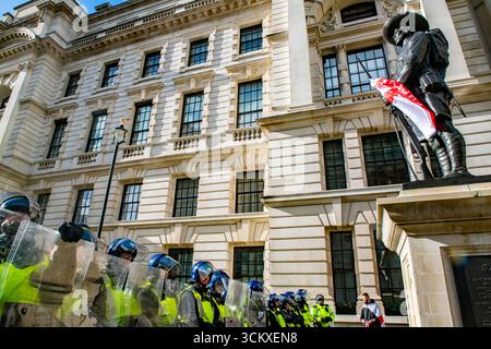 Riot police and the Gurkha Memorial, Horse Guards Avenue draped in a St ...