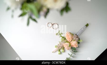 Wedding rings with bouquet and buttonhole on wooden background Stock ...