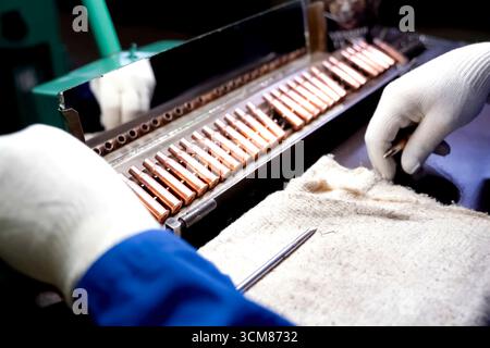 A conveyor line of cartridge cases and bullets is quality controlled by ...