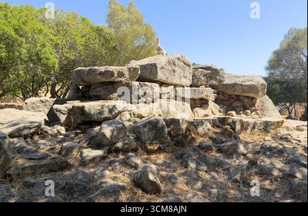 Prehistoric Giants' Tomb ruins surrounded by trees and dry landscape ...