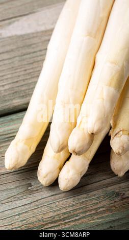 Vibrant green asparagus arranged on sleek black plate with red chili ...
