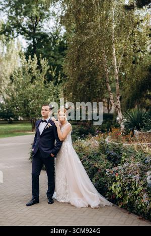 bride and groom stand in the park under a tree Stock Photo - Alamy