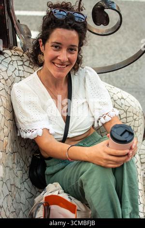 Woman smiling, holding a reusable coffee cup, inside a car Stock Photo ...
