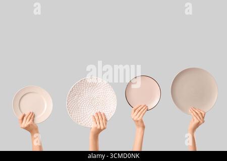 Female hands holding different plates on white background Stock Photo ...