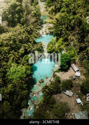 Lush tropical landscape with cascading waterfalls and a stone bridge ...