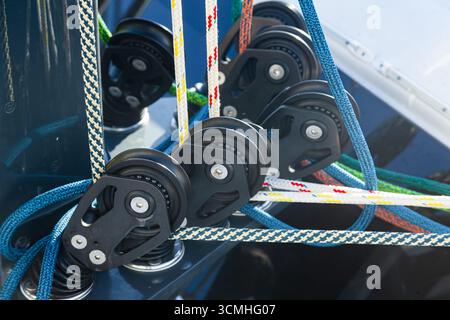 Part of the hull of a sailing yacht with multi-colored ropes, rollers ...