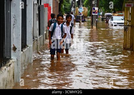 Children wade through floodwaters in a neighborhood in Maputo ...
