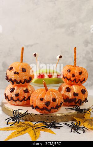 Scary monsters and ghosts made of apples and tangerines on old concrete ...