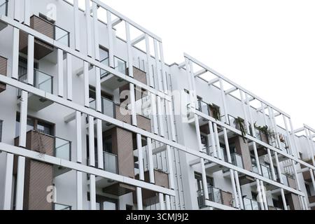 Modern apartment building facade with bold orange, gray, white, and ...