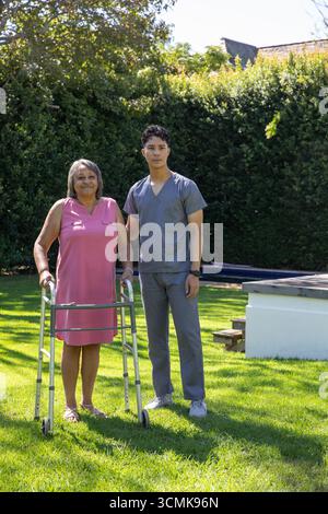 Young south asian woman standing over pink background with hand on chin ...