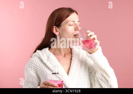 Woman rinsing mouth with mouthwash on white background. Oral hygiene ...