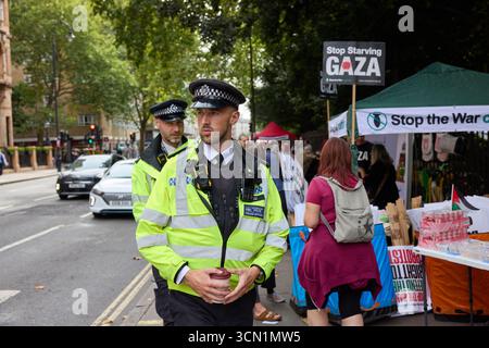 Metropolitan police officers walking passed pro palestine signs Stock ...