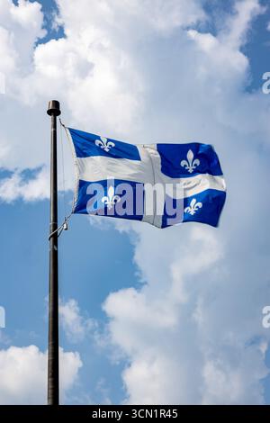 Québec flag with blue fleurdelisé waving outdoors, symbol of culture ...