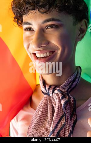 Person wearing rainbow flag, red tights and beret against a pink urban ...