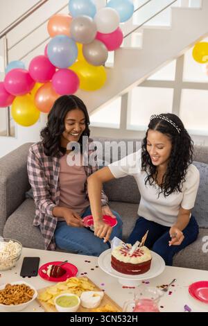 A young modern mom with pink hair holds a baby with a lollipop on a ...
