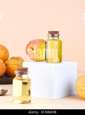 Bottles of apricot essential oil on color background with space for ...
