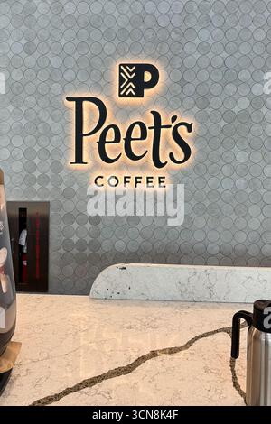 Peets Coffee logo on exterior of gray building against clear blue sky ...