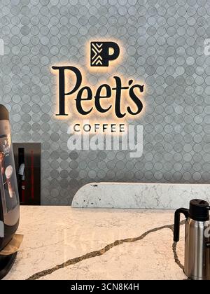 Peets Coffee logo on exterior of gray building against clear blue sky ...