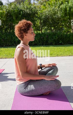 woman meditating in lotus pose at yoga studio Stock Photo - Alamy