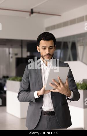 Serious, business man on tablet for research, social media content or ...