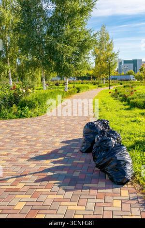 Garbage bags on footpath in city Stock Photo - Alamy