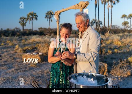 Wedding couple toasting champange at an outdoor wedding ceremony in the ...