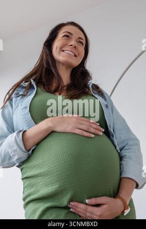 Pregnant woman caressing her belly over white background Stock Photo ...