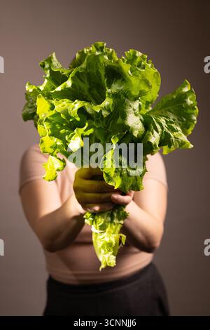 Woman covering her face with lettuce Stock Photo - Alamy
