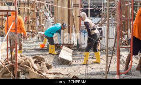 Construction workers dismantle column formwork after concrete curing ...