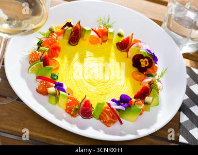 Tartar of raw salmon with ring from avocado and fresh vegetables and ...