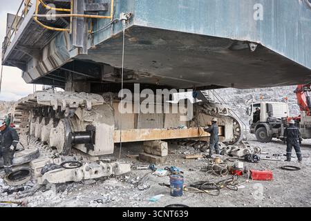 Skilled mechanics hard at work on the massive crawlers of this electric ...