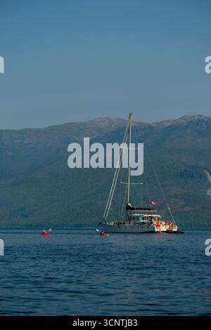 People kayaking with the SV Island Solitude at anchor near Hartley Bay ...