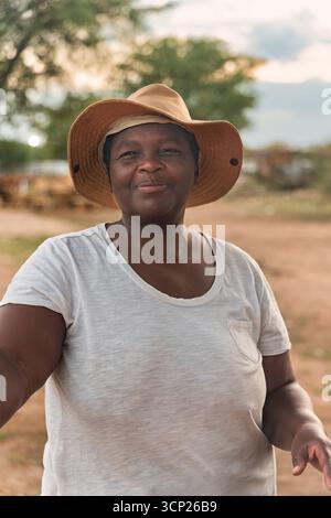 Happy mature woman wearing hat holding book enjoying sunny day Stock ...
