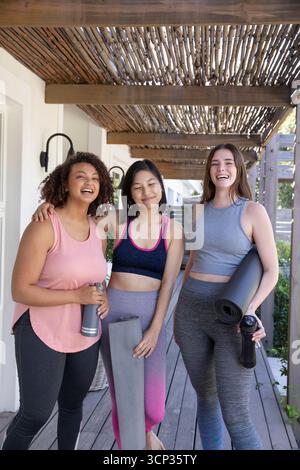 Women standing by a wall with exercise mats Stock Photo - Alamy