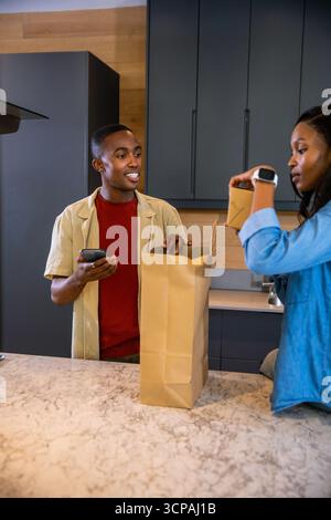 Cooking man in short-sleeves, dark-pants at kitchen-island, frying-pan ...