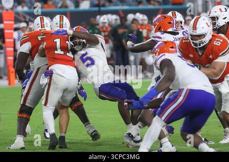 Florida Gators linebacker Myles Graham (5) and teammates tackle a Miami ...