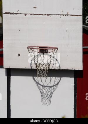 Orange basketball hoop hanging in a construction pit, behind it a ...