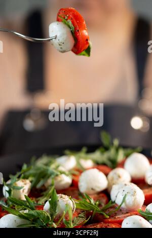 A person holds a fresh red tomato in their palm while standing in a ...