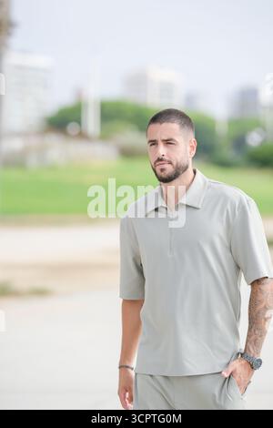 Young hispanic man with tattoos wearing business suit and tie suffering ...